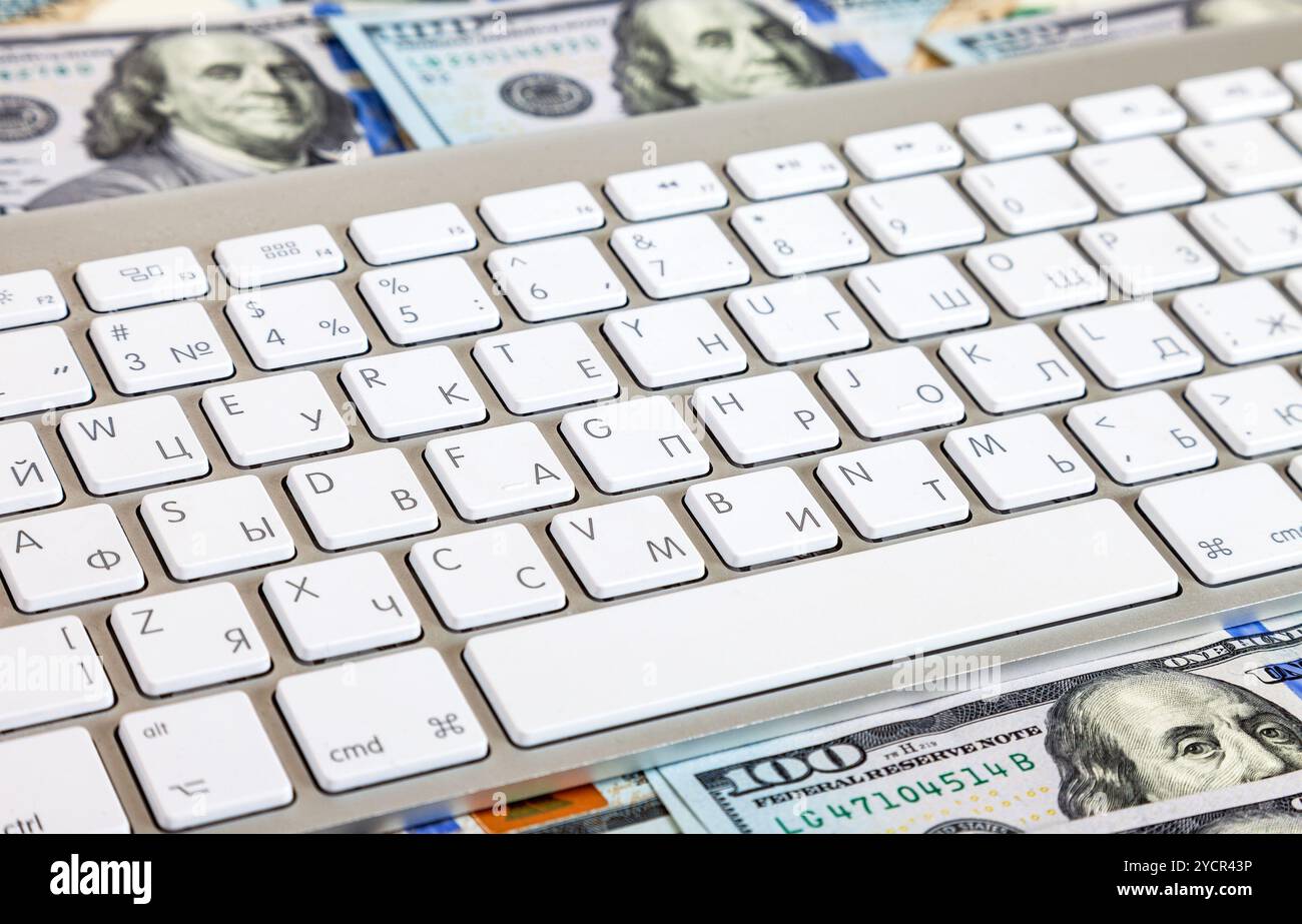Computer keyboard lying on a on the background of dollars Stock Photo ...
