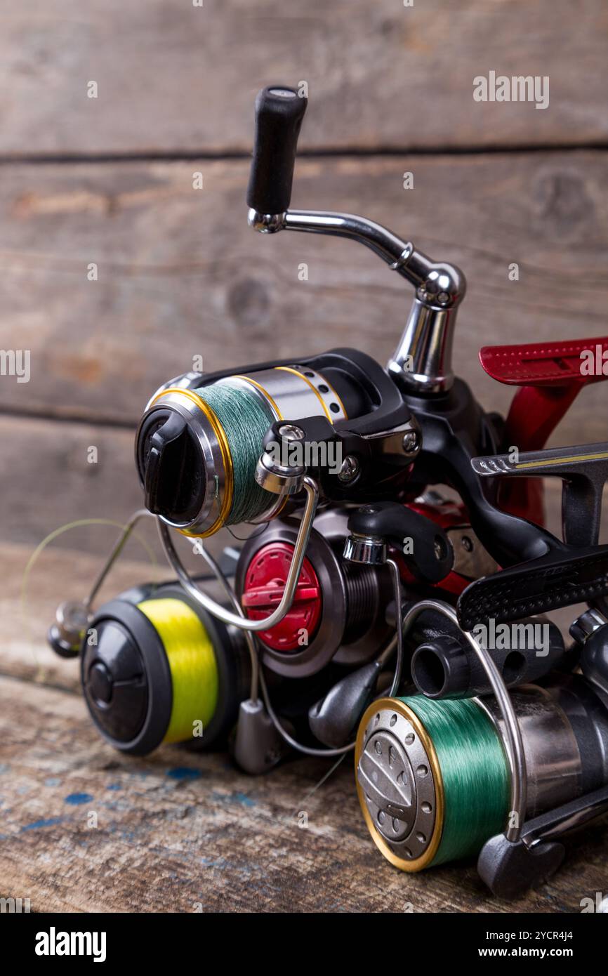 Different fishing reels with line on wooden background Stock Photo - Alamy