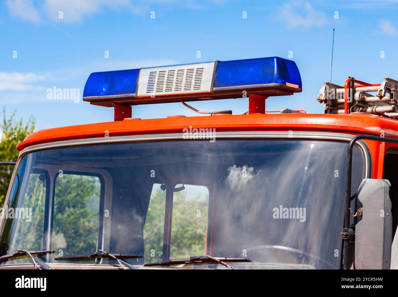 Close-up of the Flashing Blue Siren Light on roof of red firetruck ...