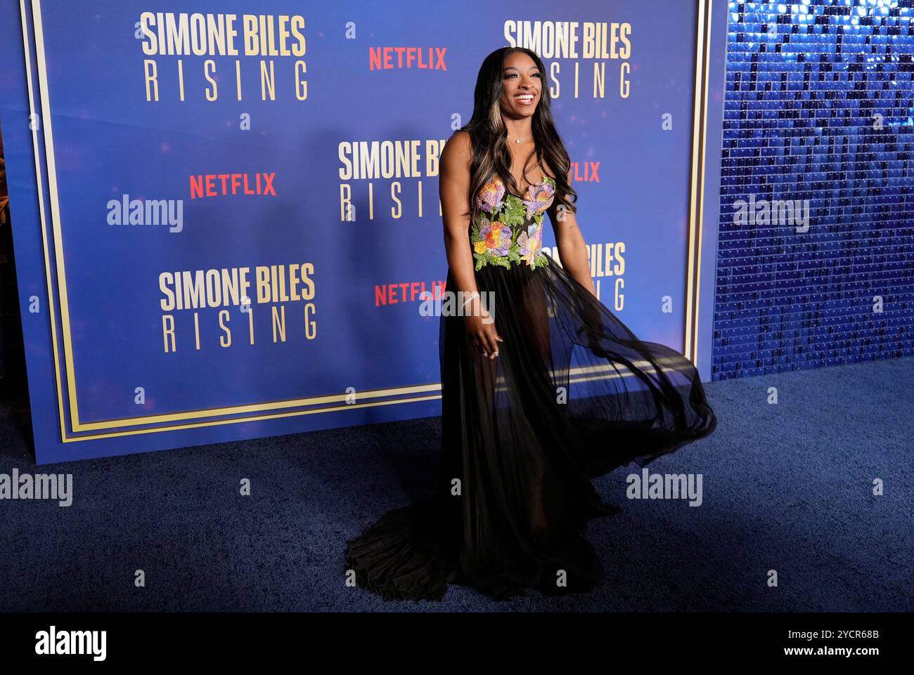 U.S. Olympic gymnast Simone Biles flares her dress as she poses at the ...