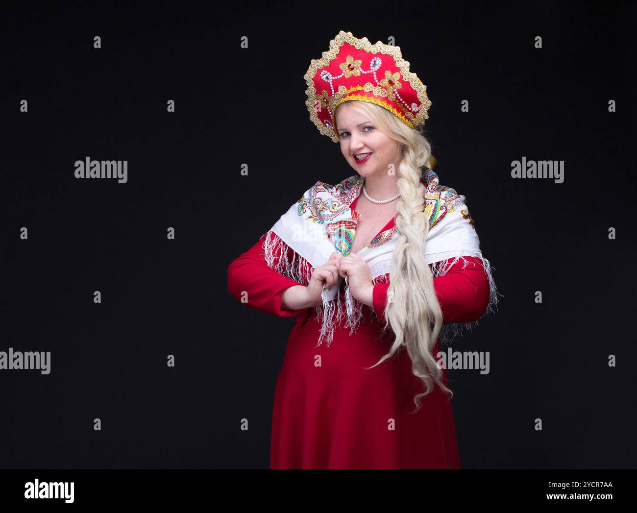 Girl standing in Russian traditional costume. Plus size Woman is wearing sarafan and kokoshnik ...