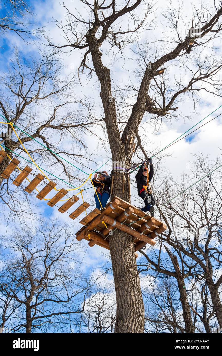 Boy and girl with climbing equipment ready for the passage of obstacles ...