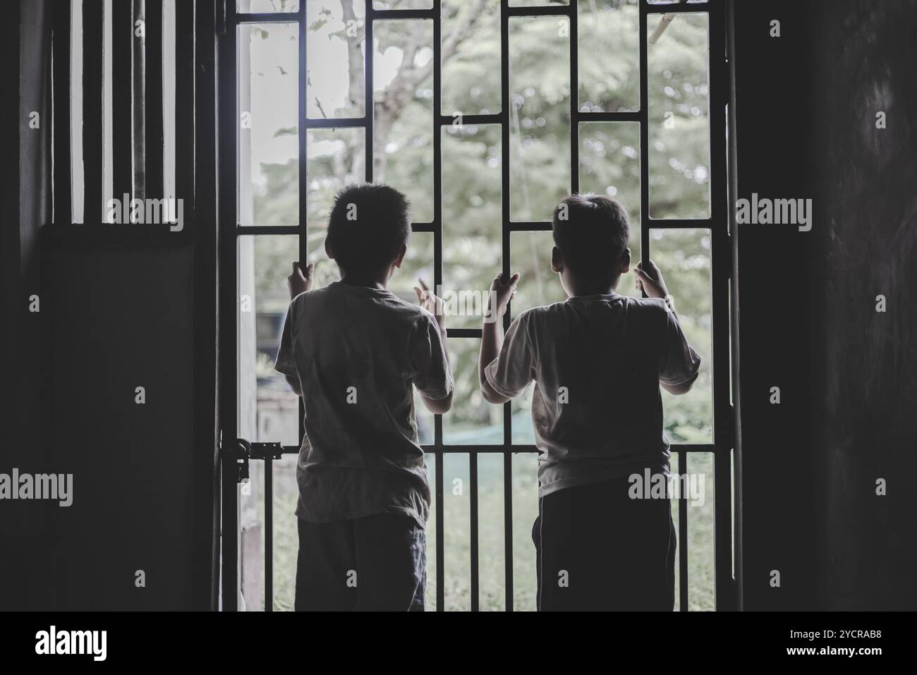 The back of two children locked in an iron cage. victim child with ...