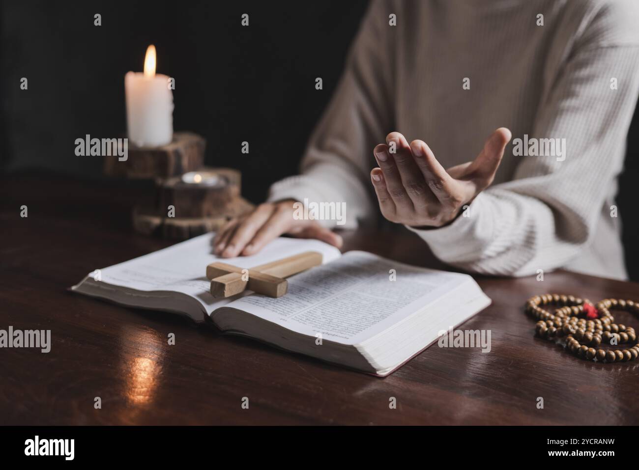 Woman praying with the bible on the table. The hand of a Christian ...