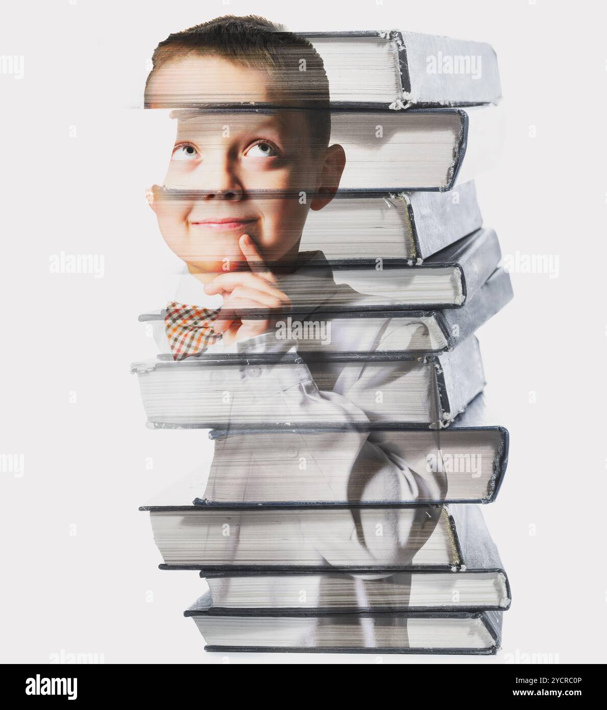 thinking school boy mixed with pile of books, against gray background ...