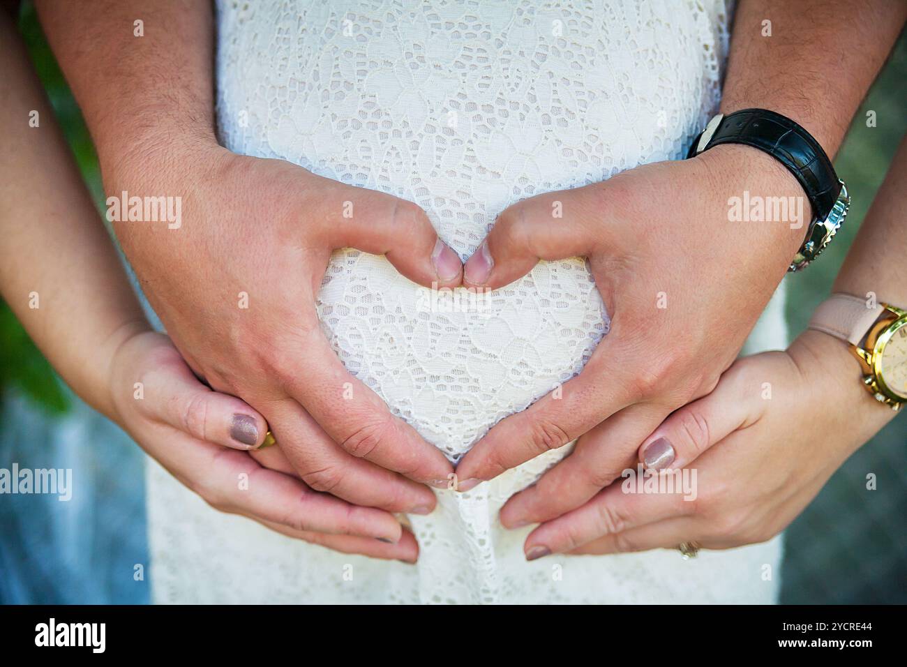 Pregnant women wrap her arms around the belly in the form of the heart ...
