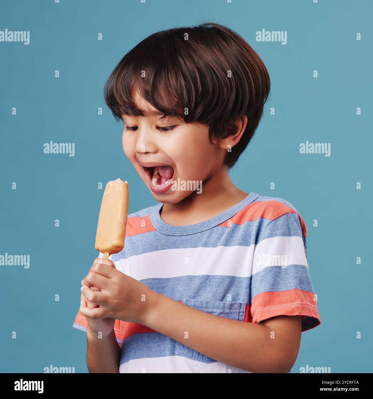Japanese boy, bite and popsicle in studio background with sweet snack ...