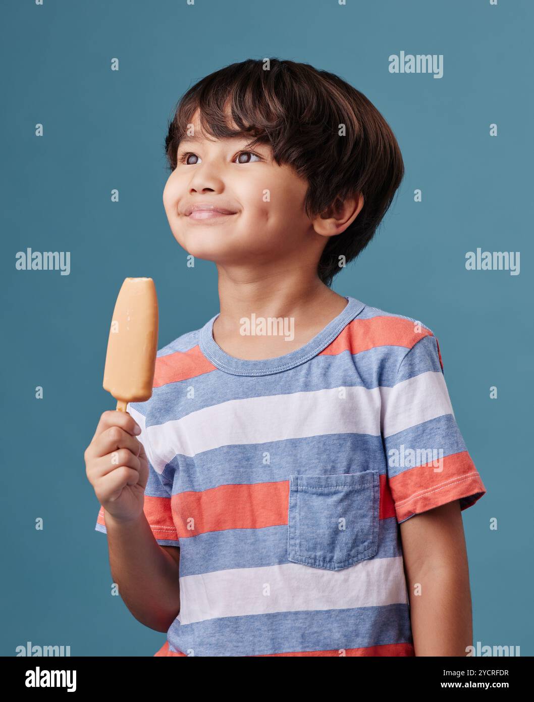 Japanese boy, happy and popsicle in studio background with sweet snack ...