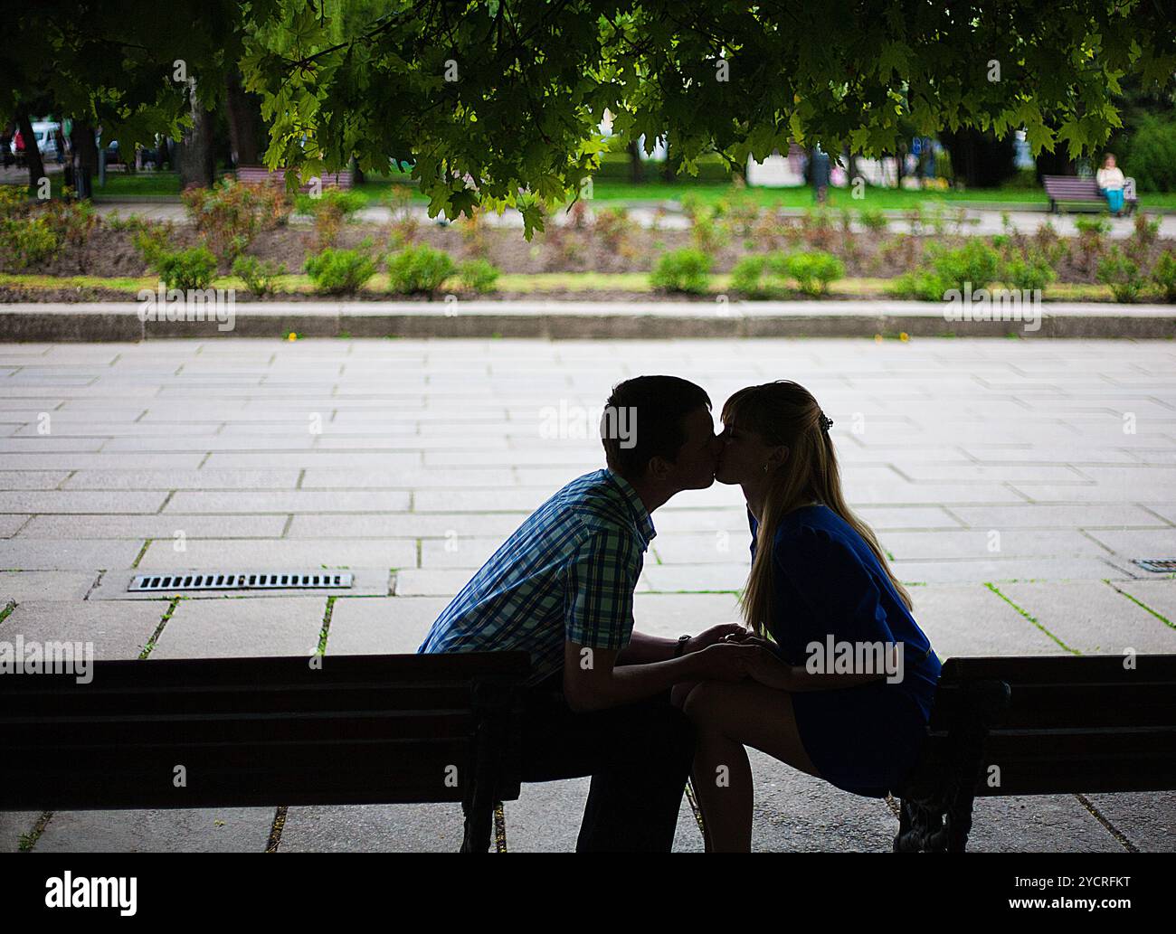 Couple kissing on park bench hi-res stock photography and images - Alamy