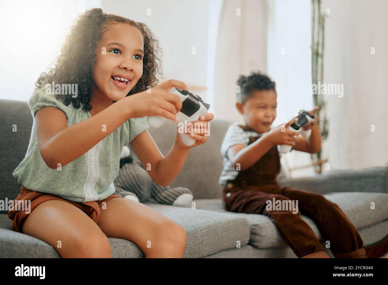 Happy, controllers and children on sofa with video game for bonding ...