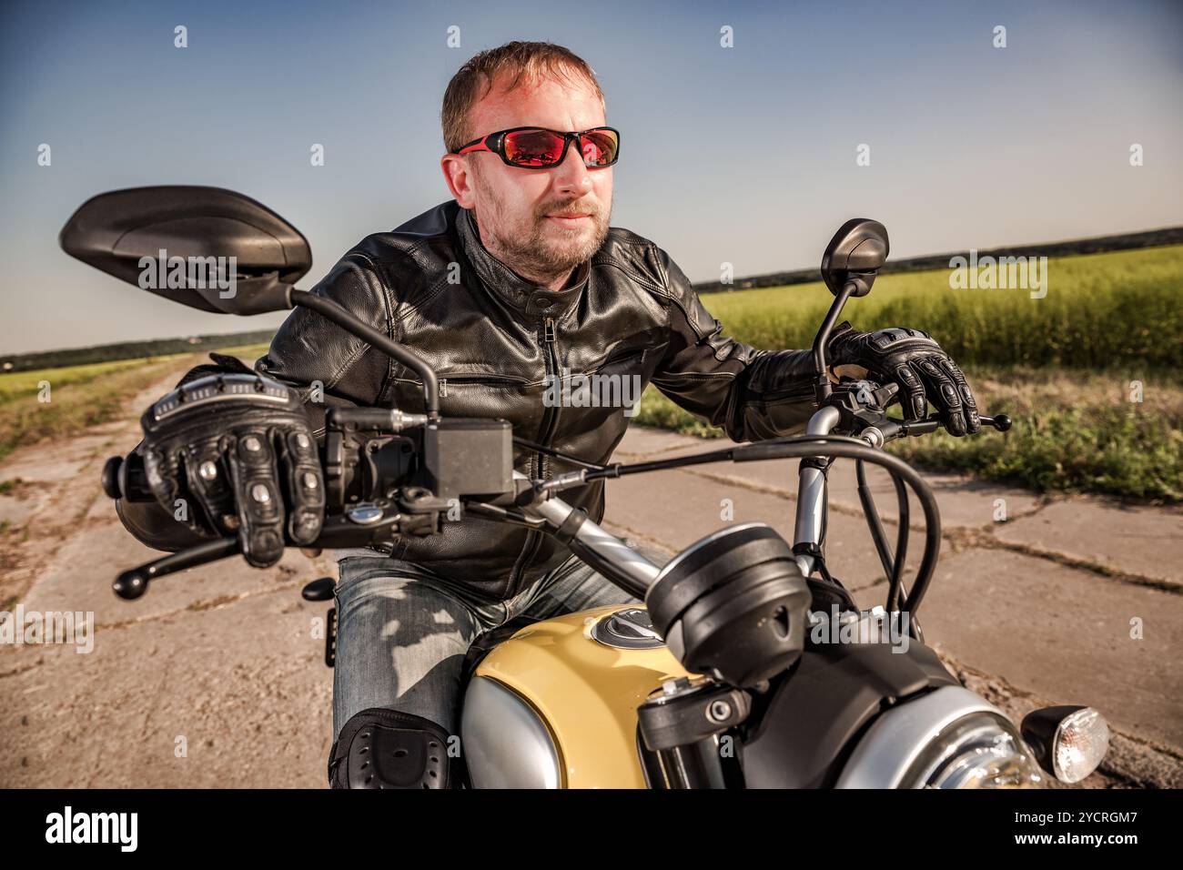 Biker in a leather jacket riding a motorcycle on the road. Filter ...