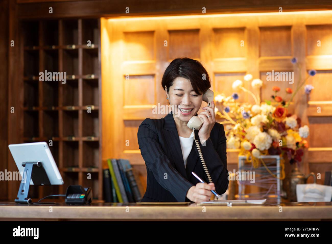 Concierge woman answering the phone Stock Photo - Alamy