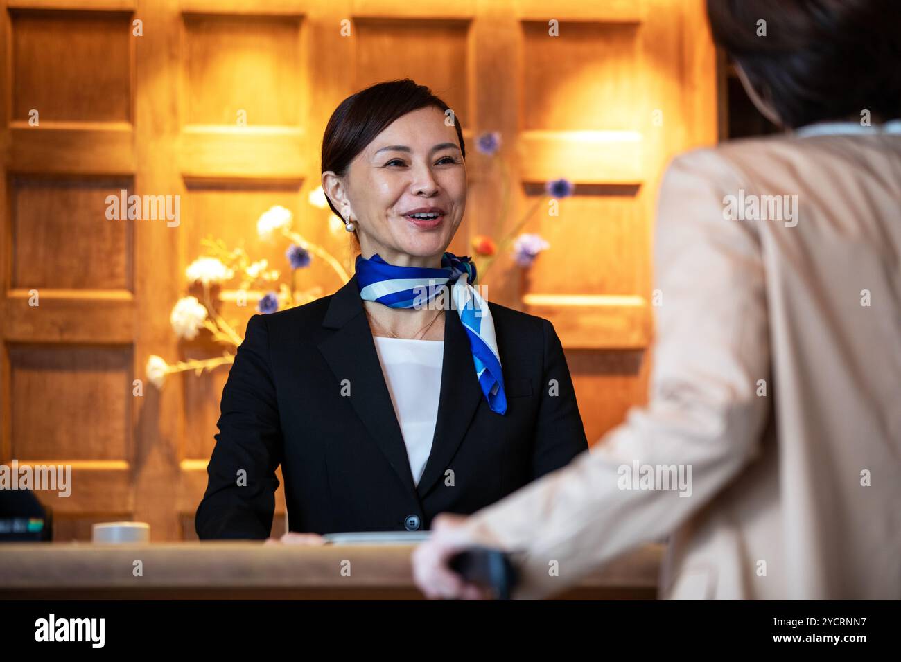 Woman at front desk serving customers Stock Photo - Alamy