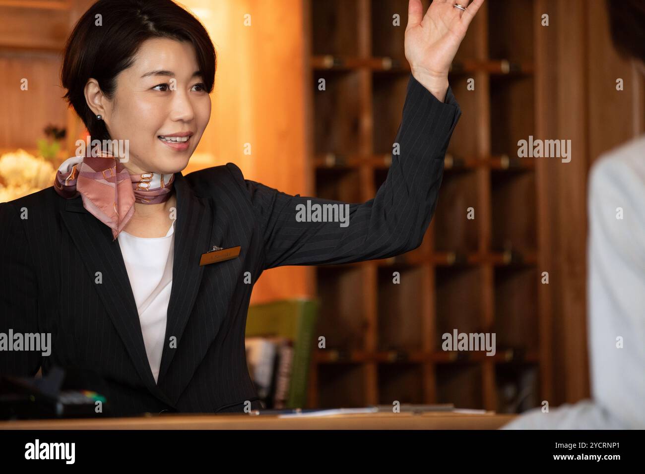 Woman at front desk serving customers Stock Photo - Alamy