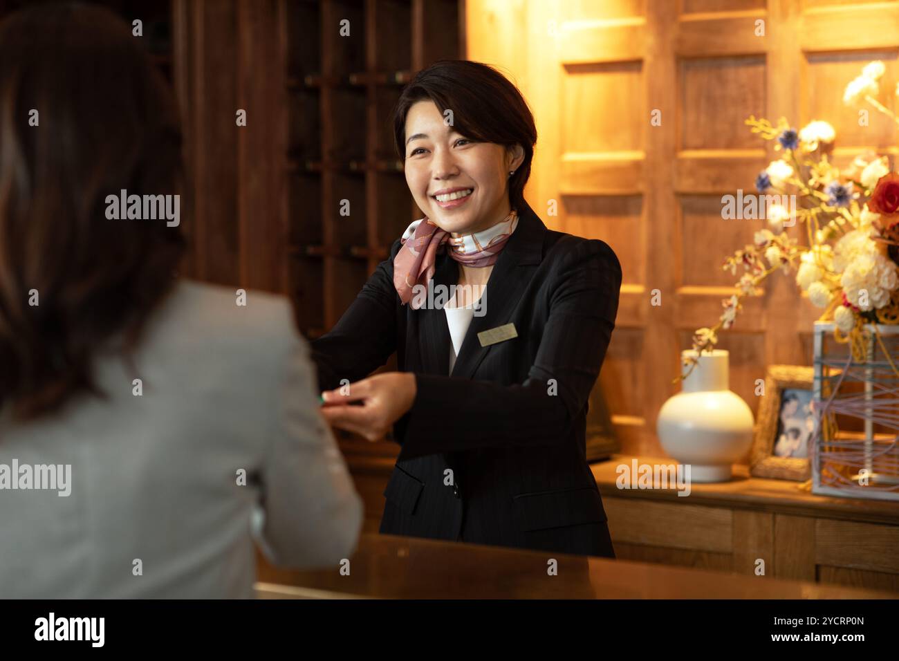 Woman at front desk serving customers Stock Photo - Alamy