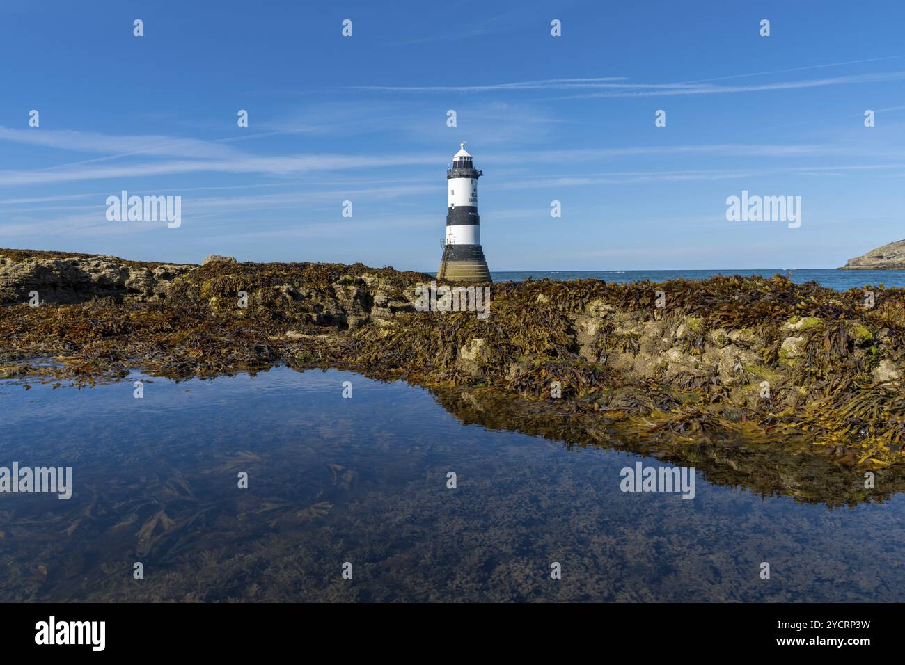 A view of the Penmon Lighthouse in North Wales with a tidal pool in the ...