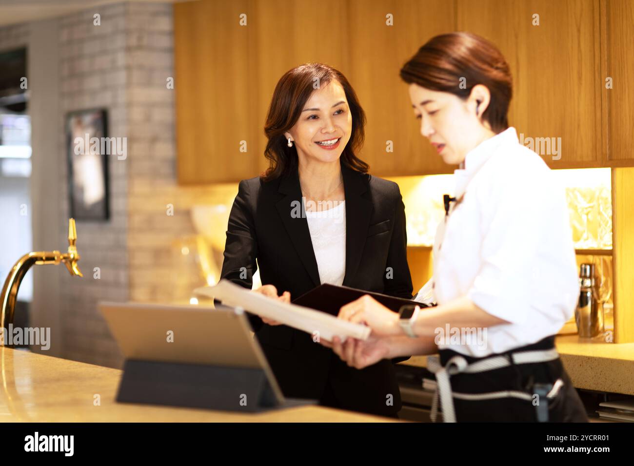 Café owner and female waitress discussing the menu Stock Photo - Alamy