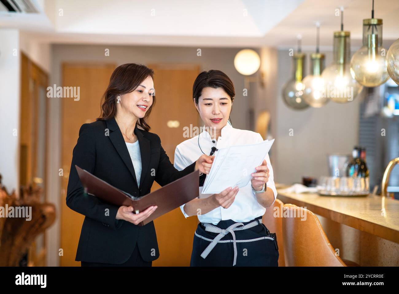 Café owner and female waitress discussing the menu Stock Photo - Alamy