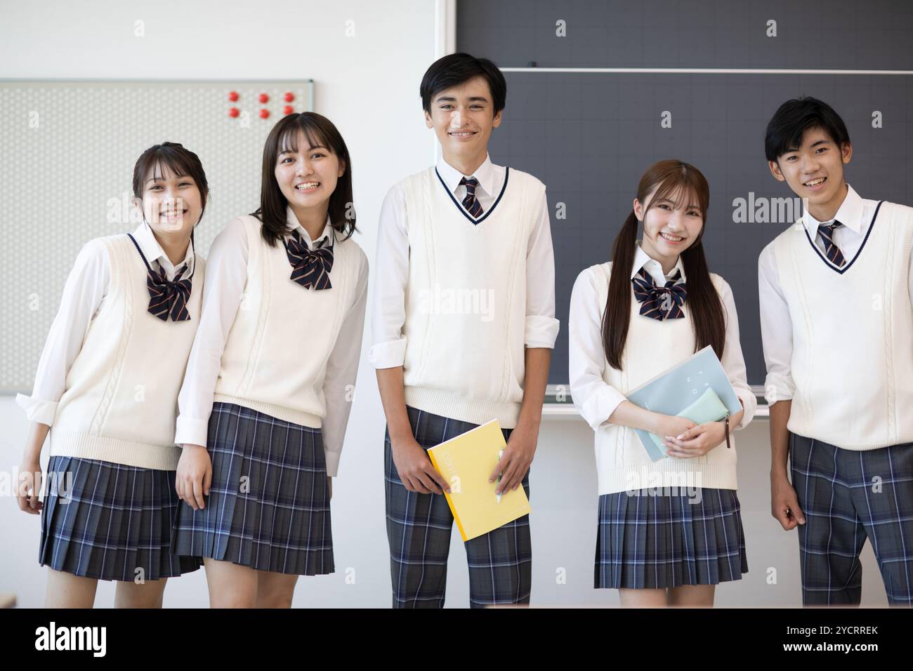 Smiling students with friends in a classroom Stock Photo - Alamy