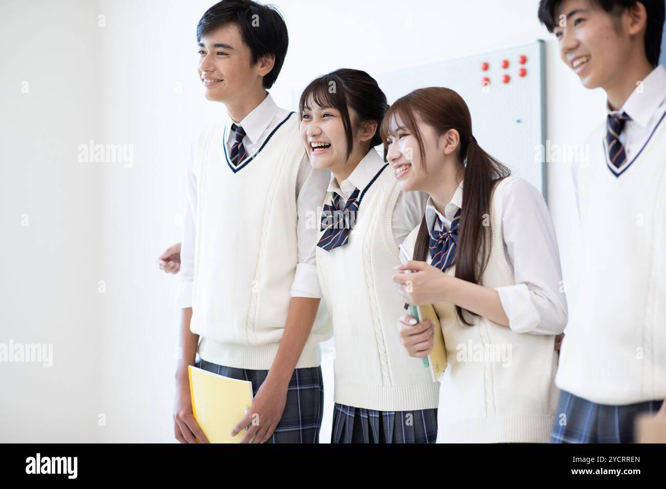 Smiling students with friends in a classroom Stock Photo - Alamy
