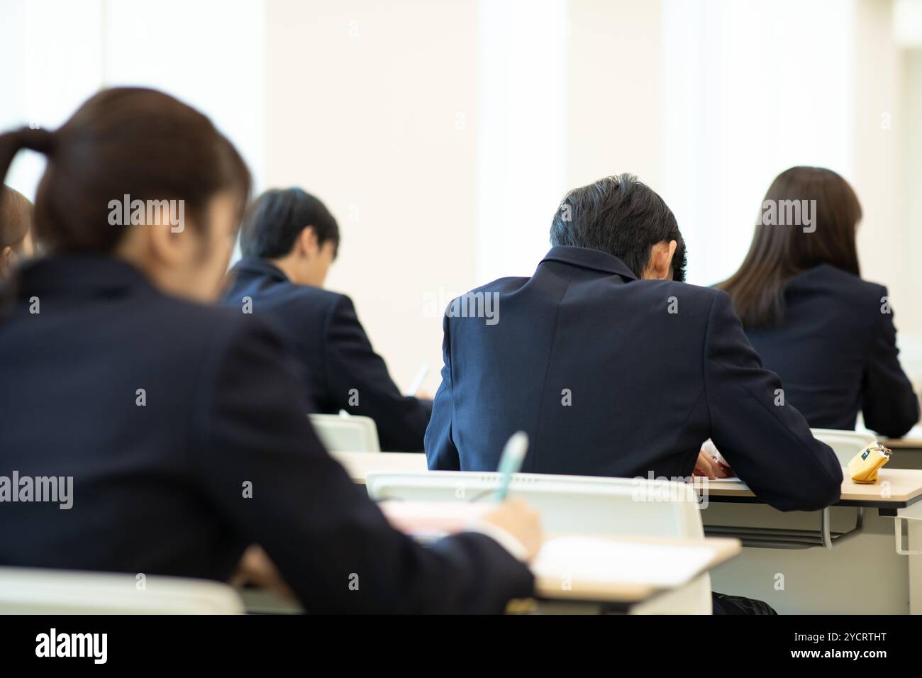 Rear view of students taking a class in a classroom Stock Photo - Alamy