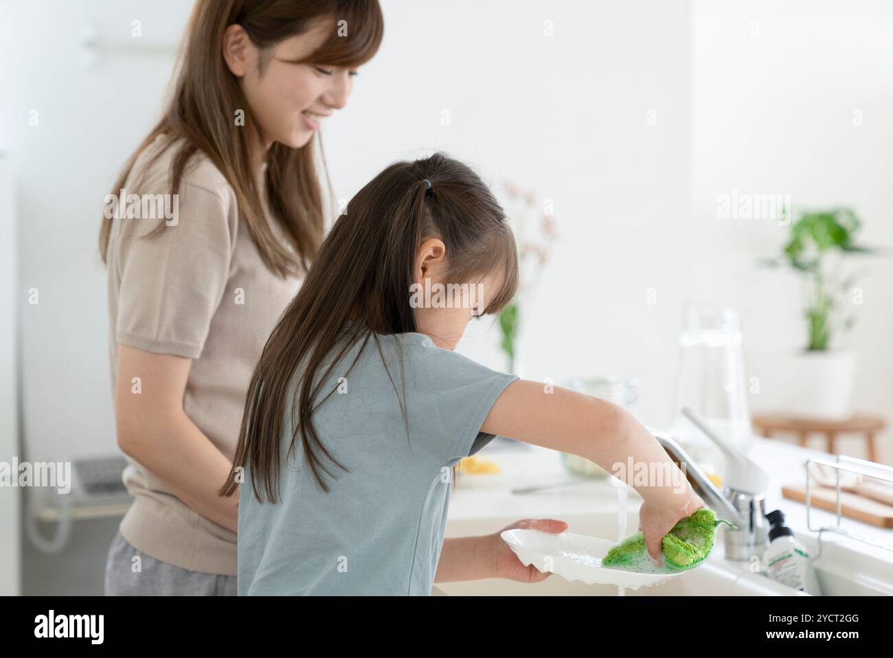 Parent and child washing dishes Stock Photo - Alamy