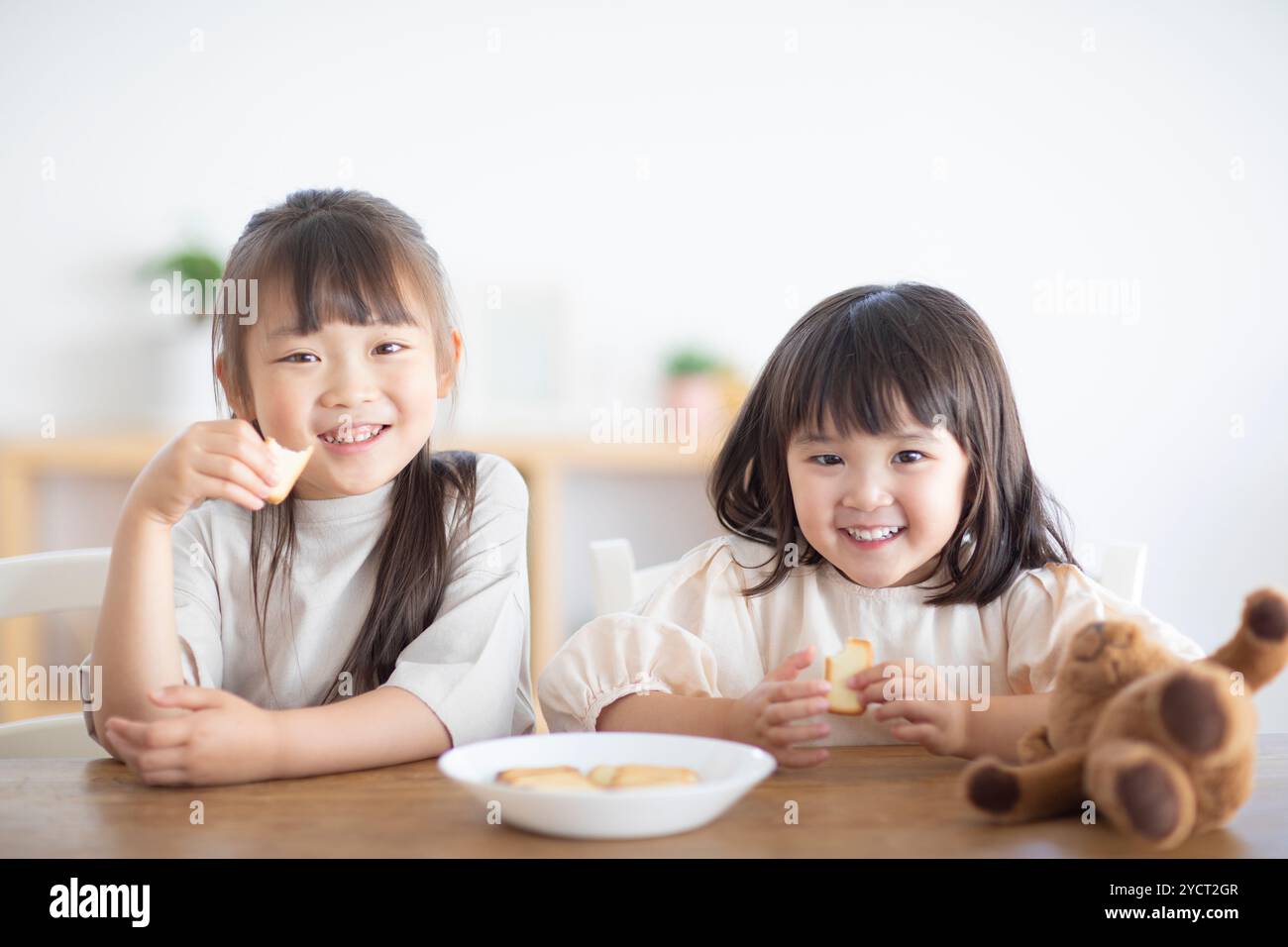 Sisters eating a snack Stock Photo - Alamy