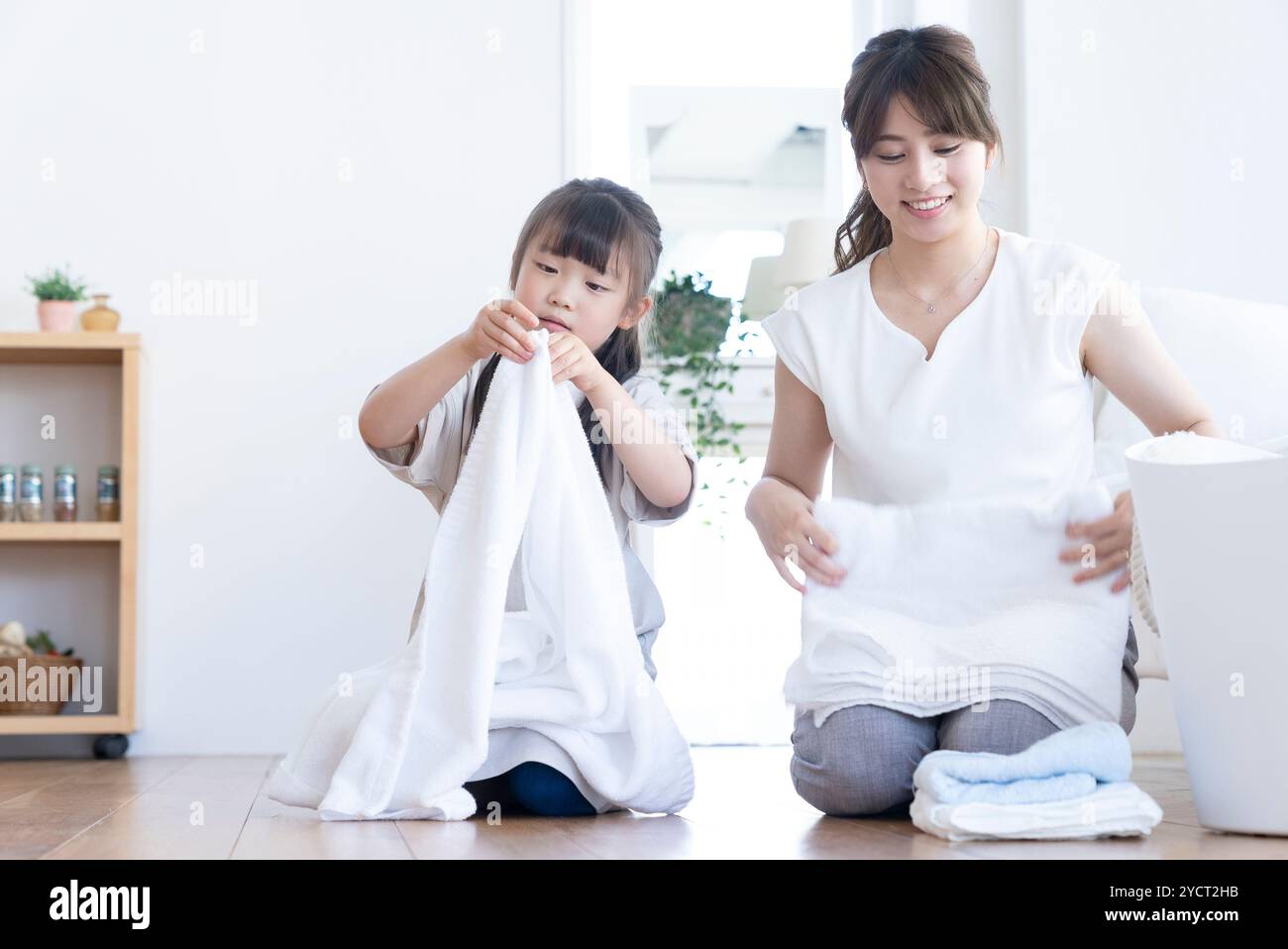 Parent and child folding laundry Stock Photo - Alamy