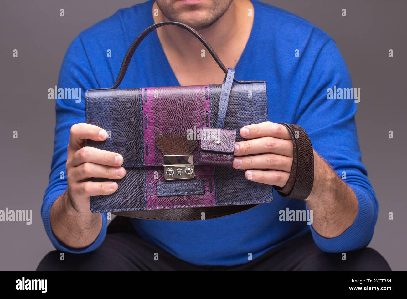 Strong male hands holding handbags Stock Photo - Alamy