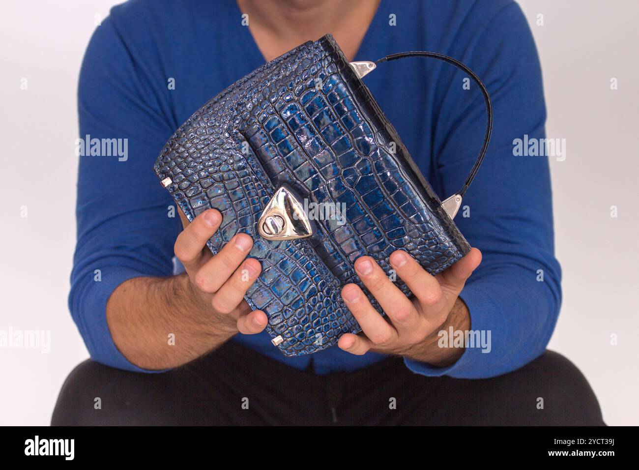 Strong male hands holding handbags Stock Photo - Alamy