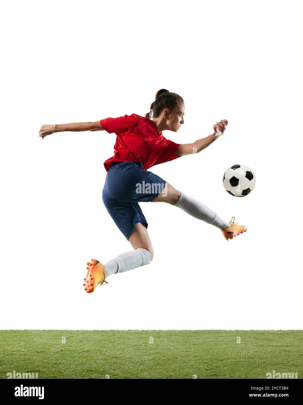 Young, athlete, female football player intense action captured mid-kick ...