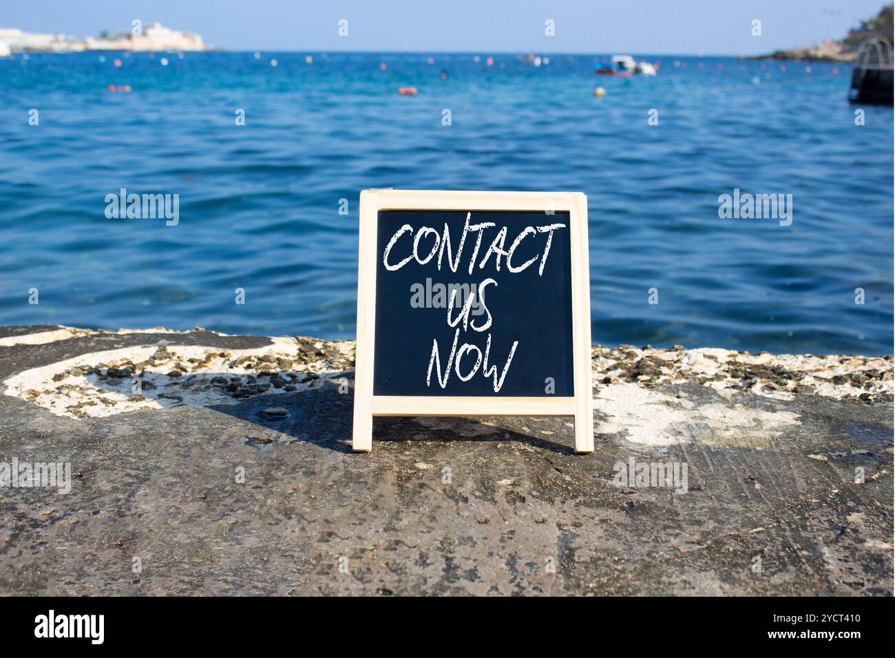 Contact us now symbol. Blackboard with words Contact us now. Beautiful ...