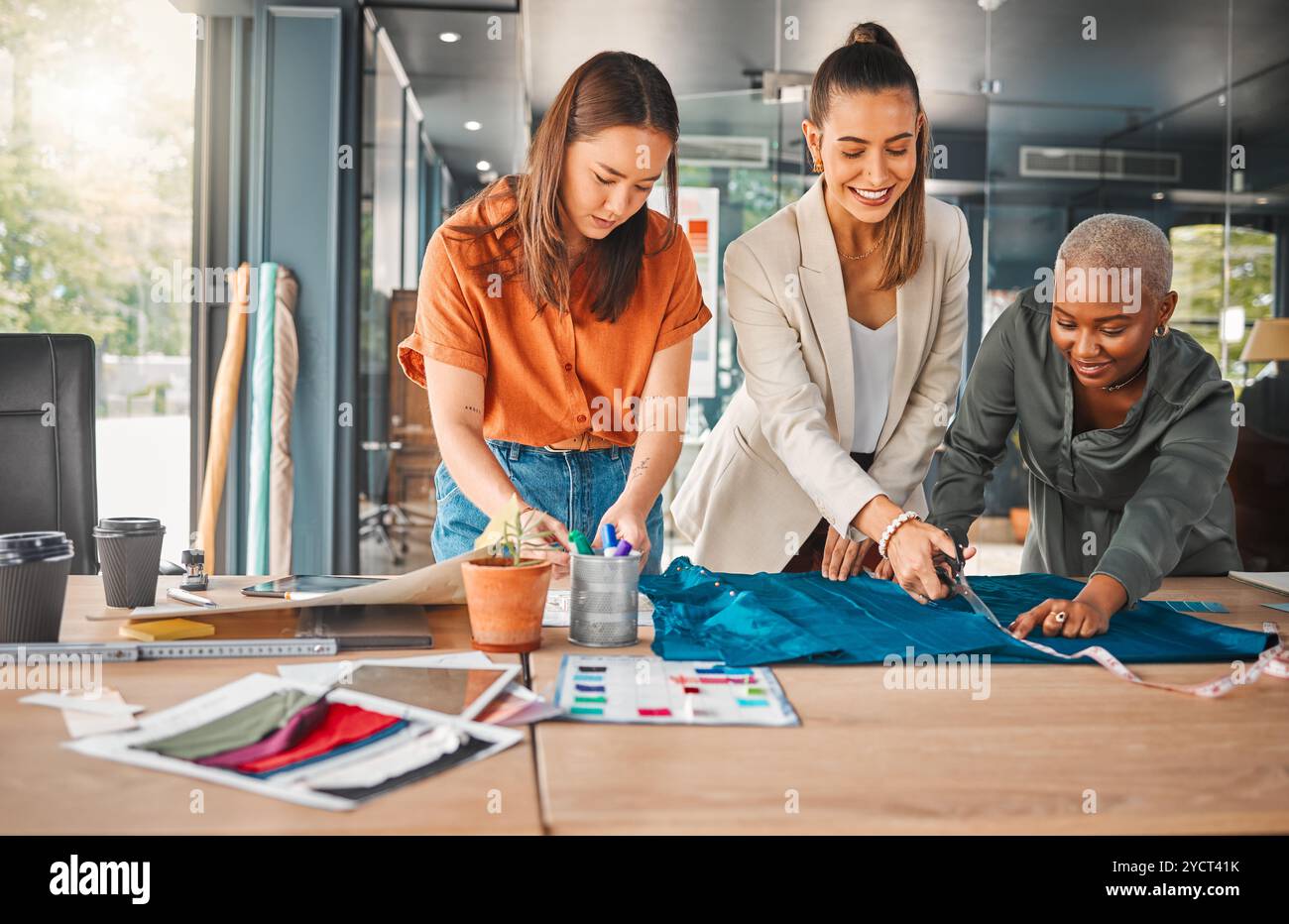Happy, women and cutting fabric as fashion designer at office with ...