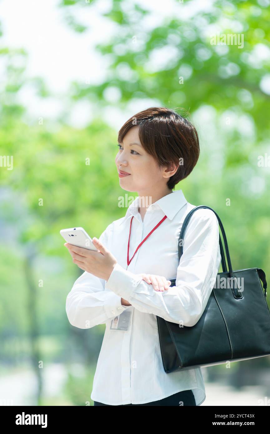 Office worker thinking with smartphone Stock Photo - Alamy