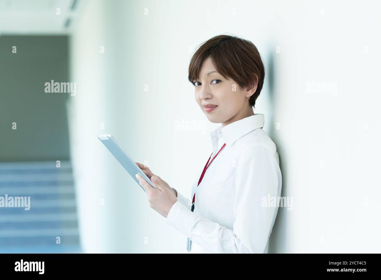 Office worker operating tablet in corridor Stock Photo - Alamy