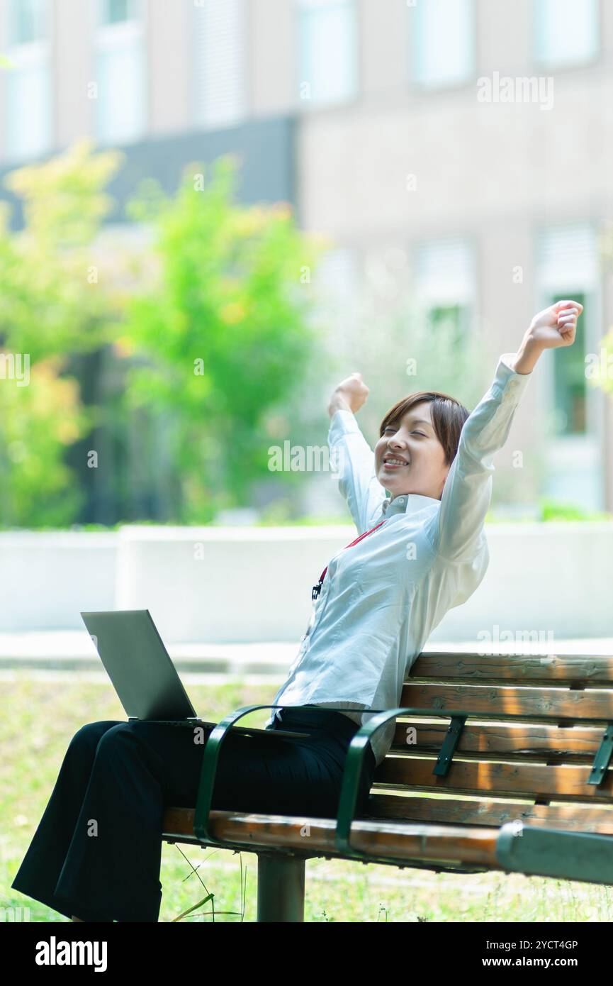 Office worker sitting on a bench and stretching Stock Photo - Alamy