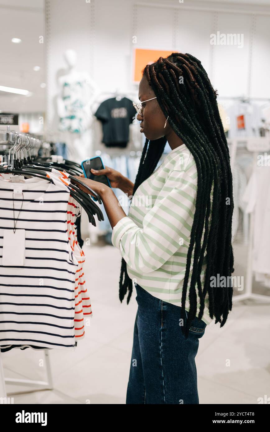 Young african american woman with dreadlocks shops for clothes in a ...