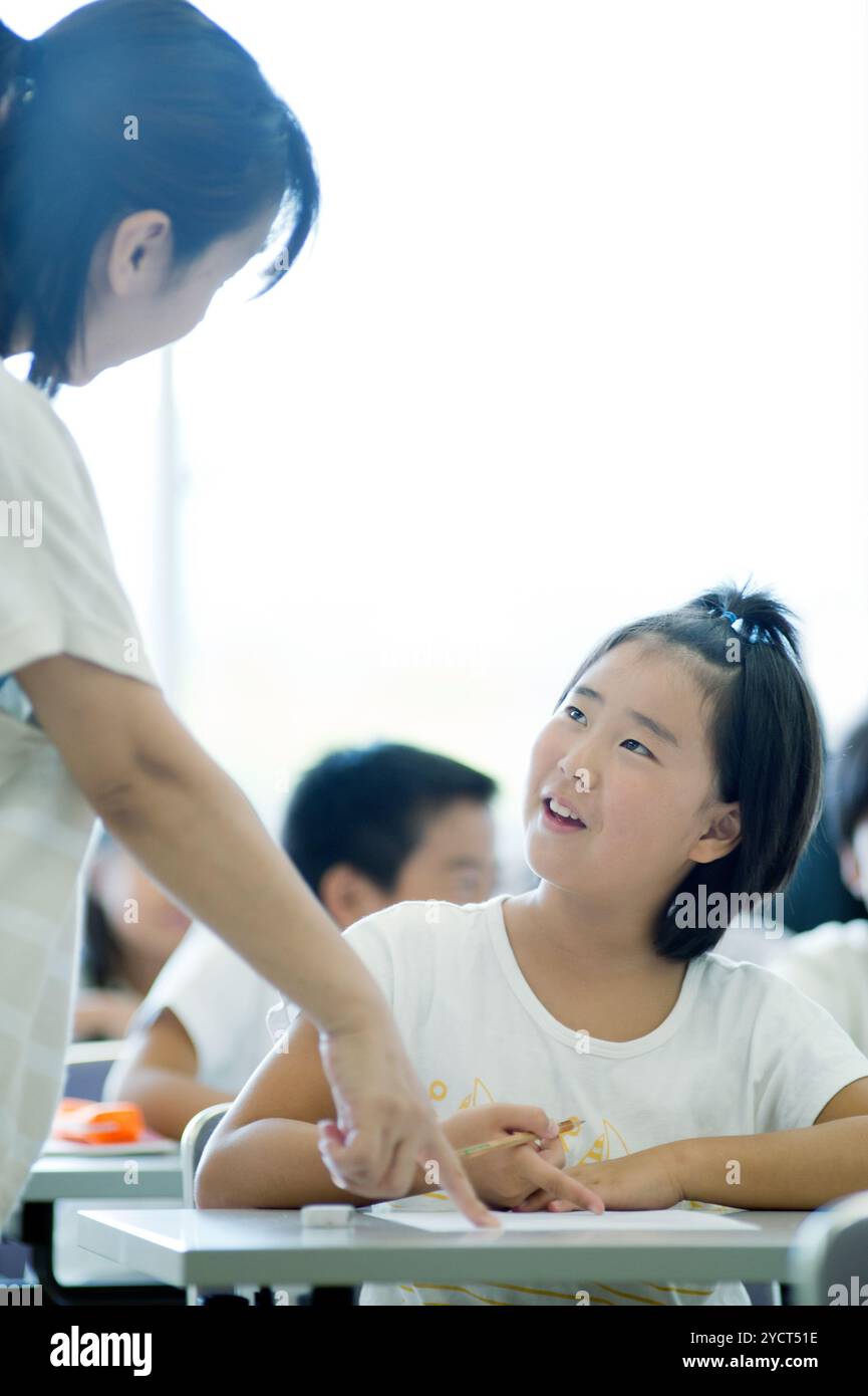 Primary schools students being taught by their teacher Stock Photo - Alamy
