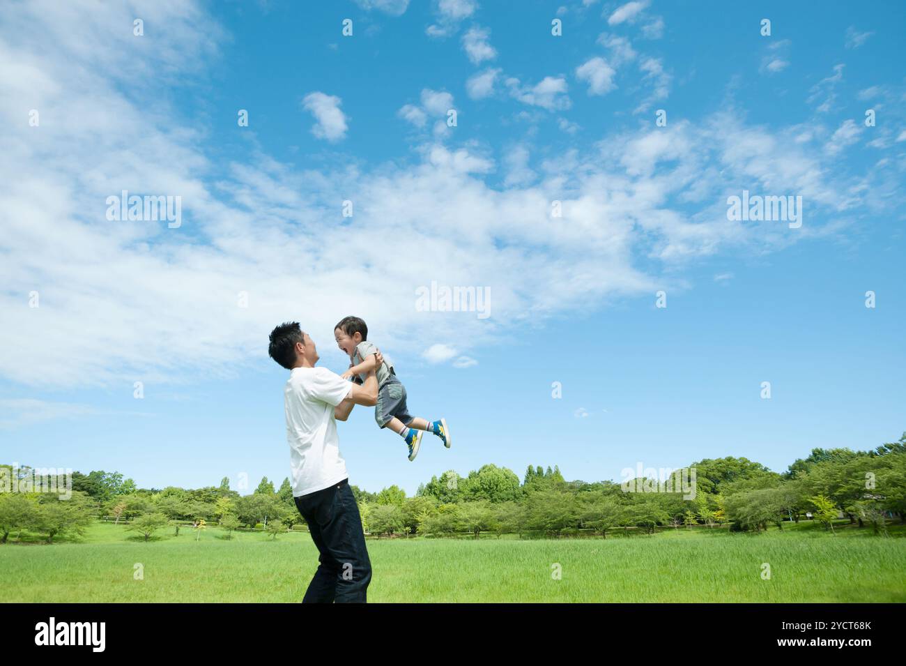 Boy happy to be given a high lift in park Stock Photo - Alamy