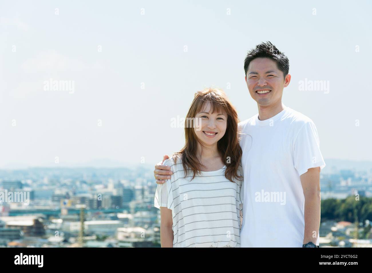 Couple standing on high ground with a view of the city Stock Photo - Alamy