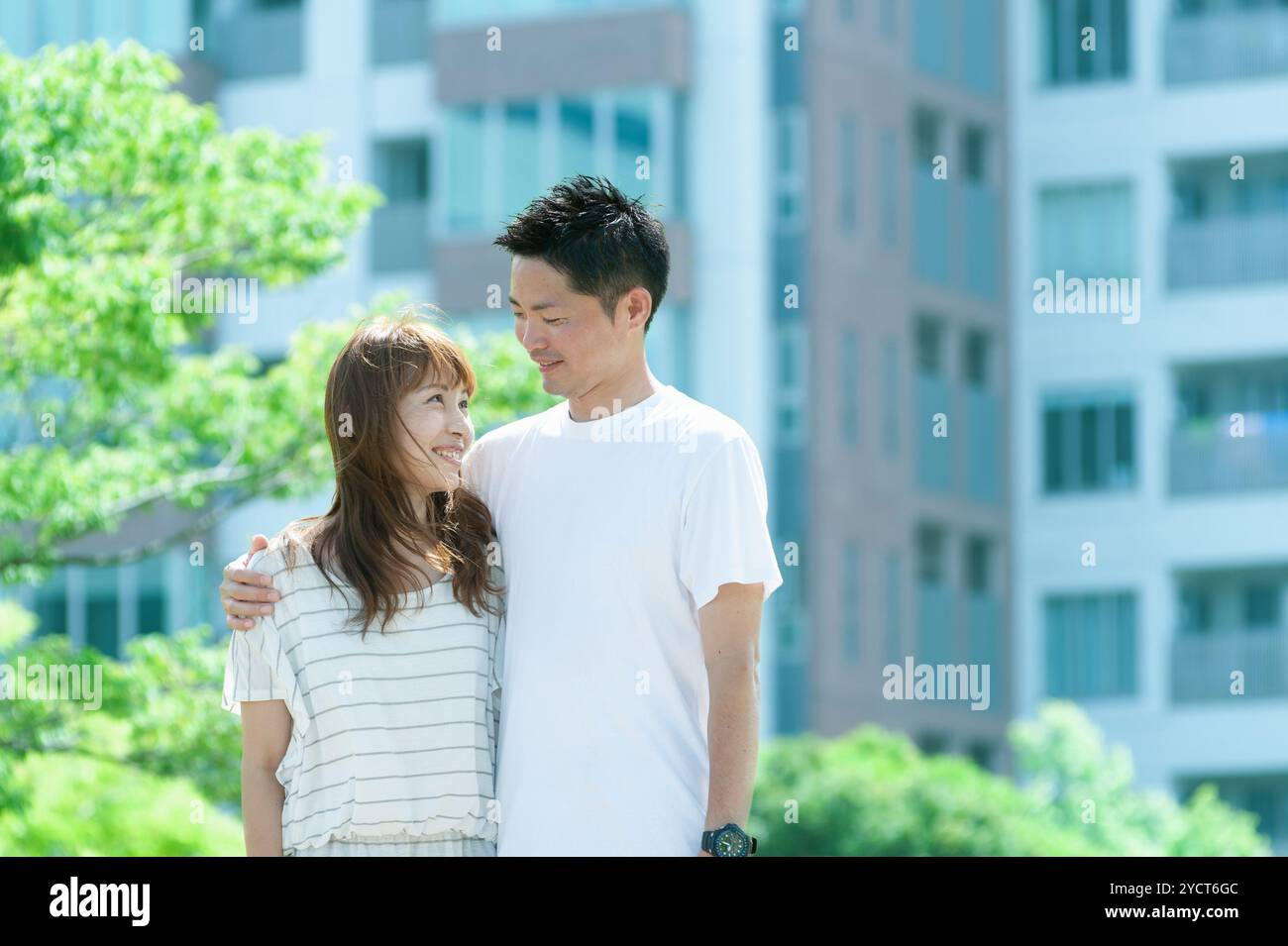 Couple standing in front of high-rise apartment building Stock Photo ...
