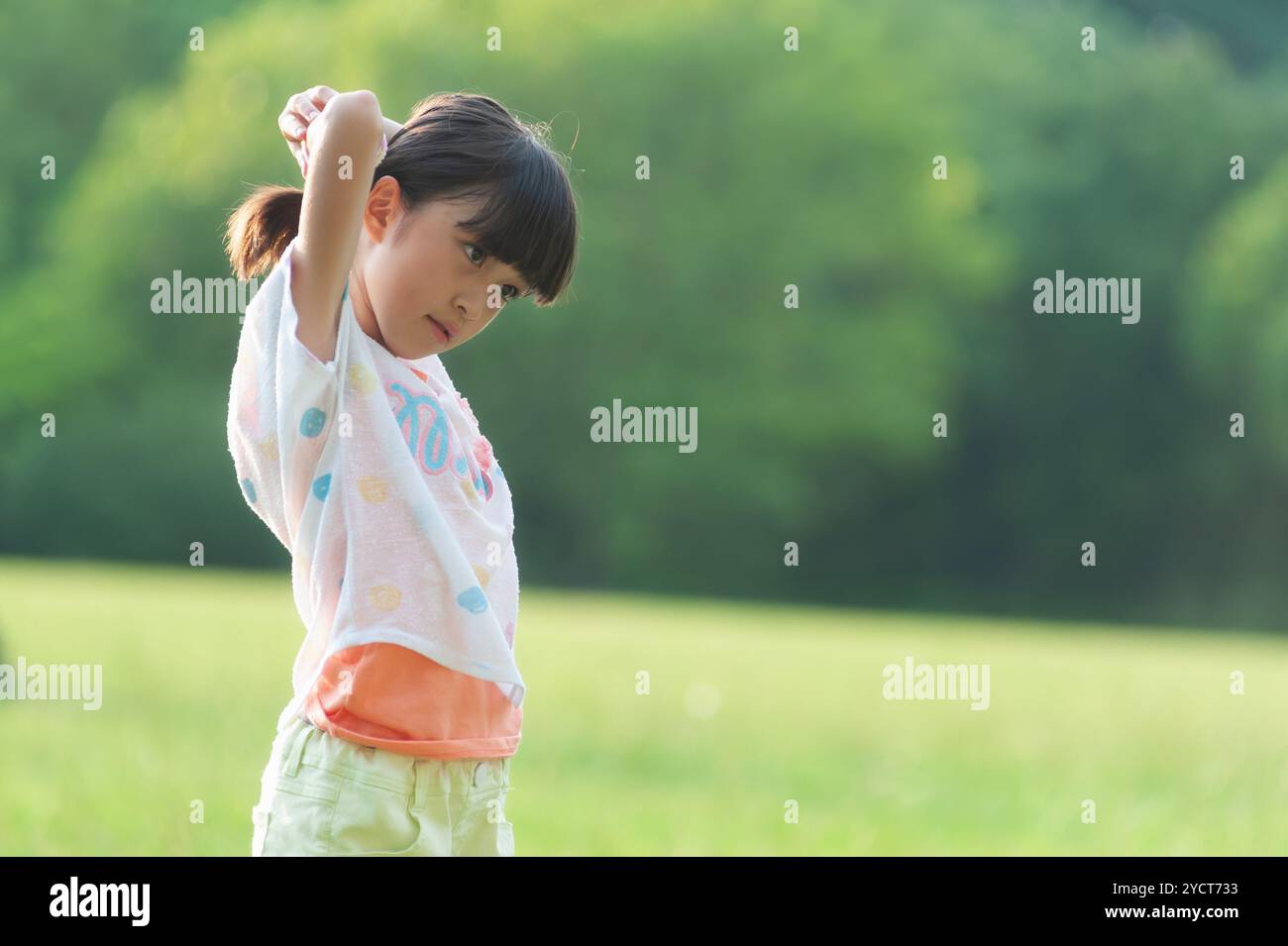 Girl tying up hair Stock Photo - Alamy