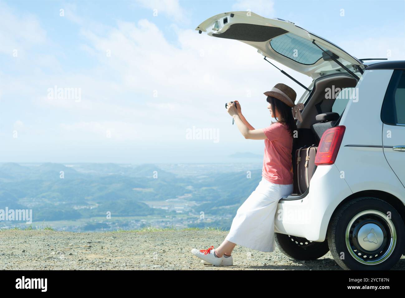 Woman sitting on trunk taking photos with digital camera Stock Photo ...