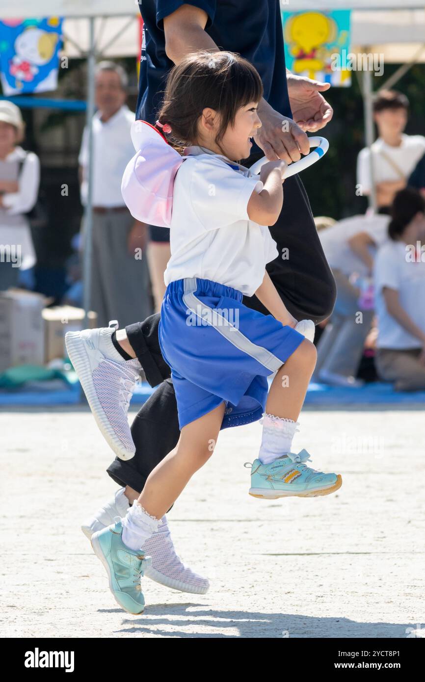A preschooler and his father compete in a parent-child event at a ...