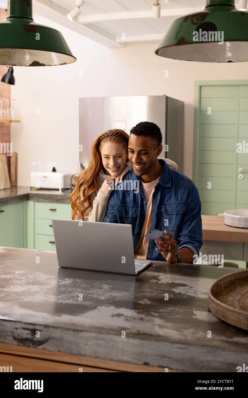 Happy multiracial couple shopping online with laptop, planning ...