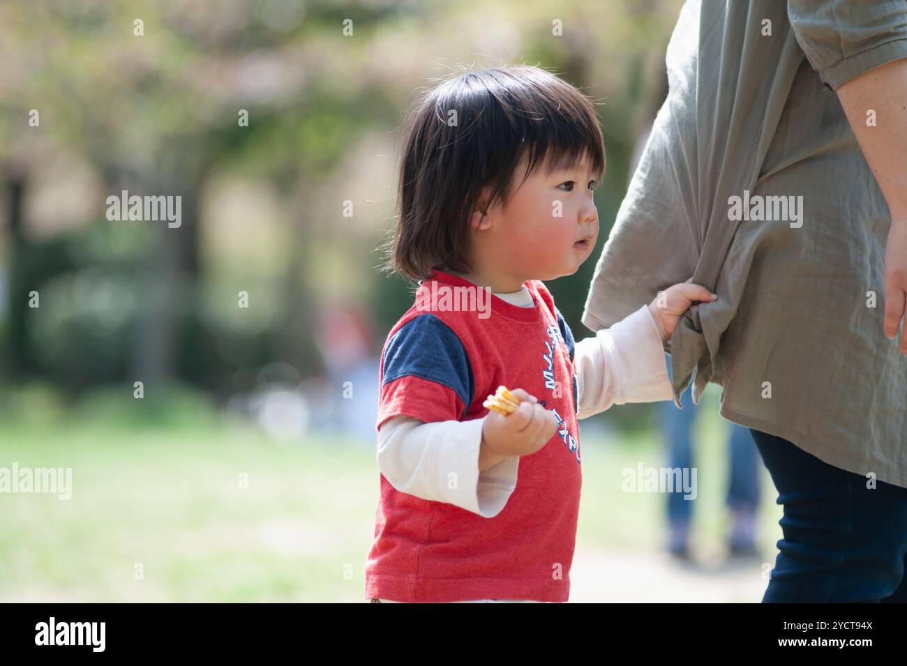 Boy clinging to mother's clothes Stock Photo - Alamy
