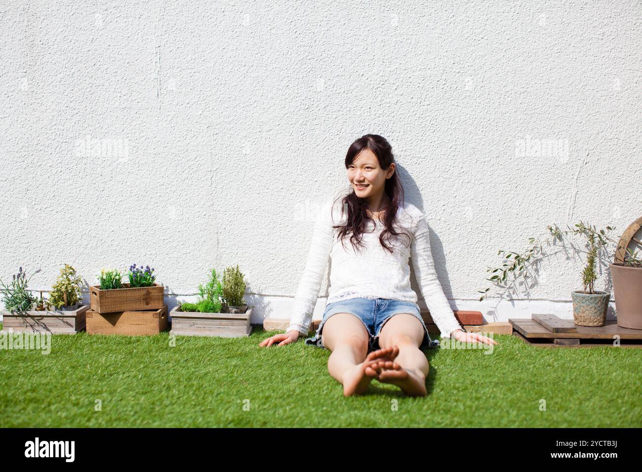Female sitting on lawn Stock Photo - Alamy