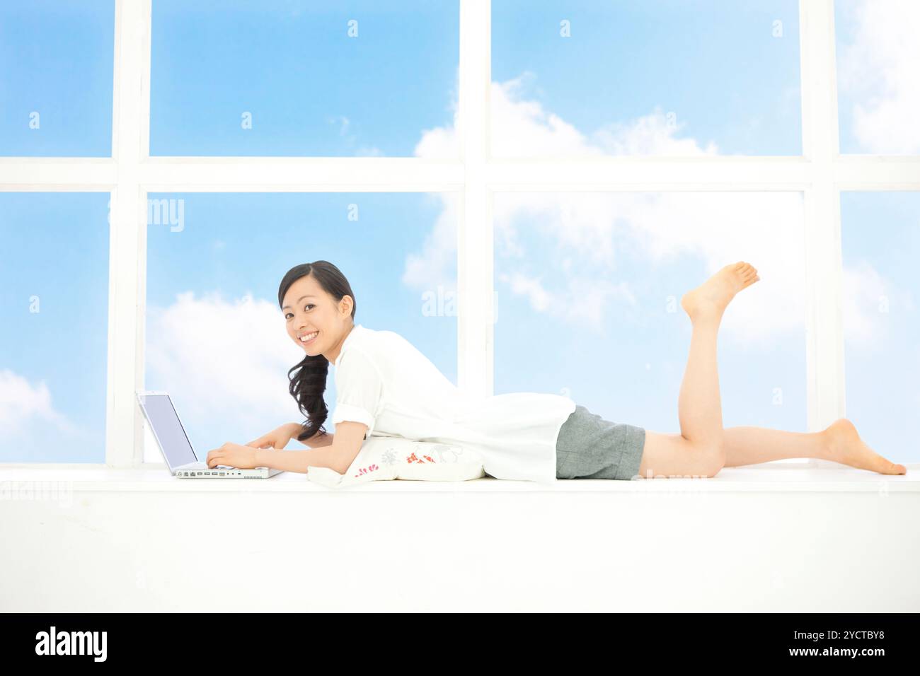 Woman lying down and opening computer Stock Photo - Alamy