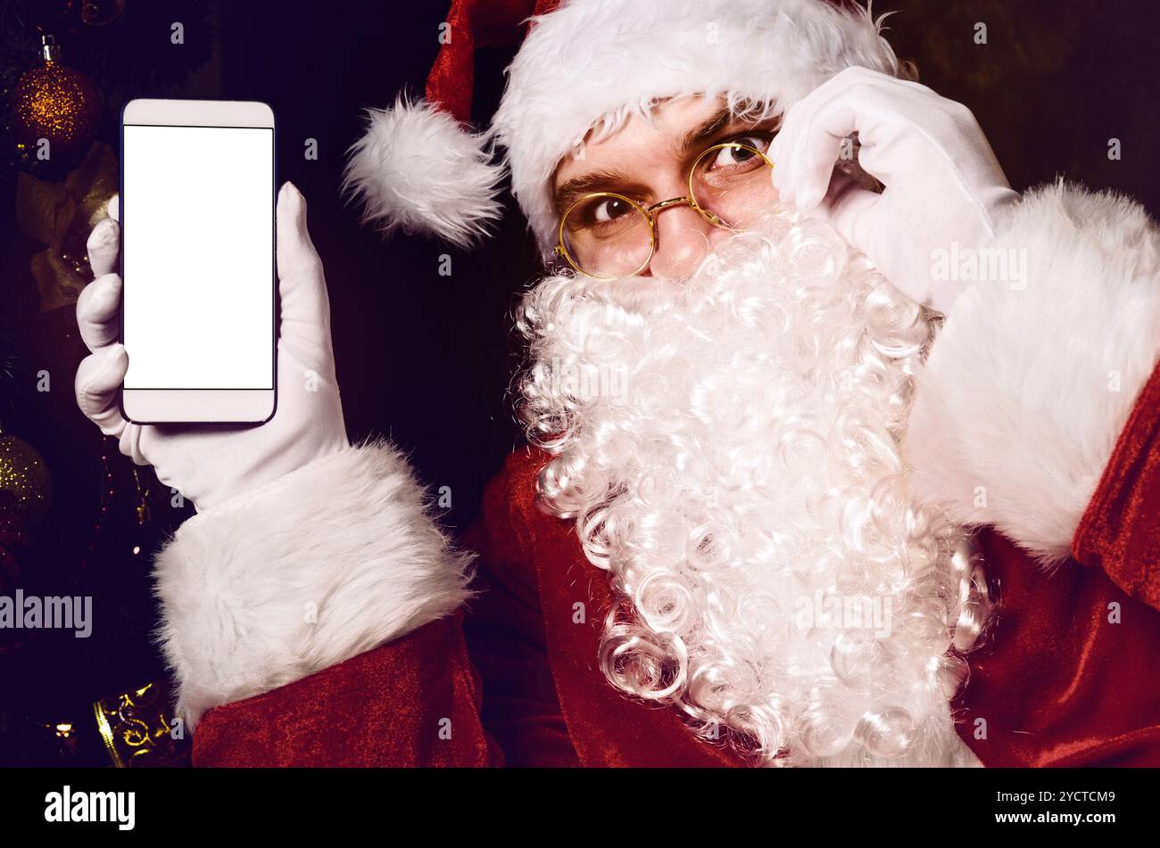 Santa Claus holding smartphone Stock Photo - Alamy