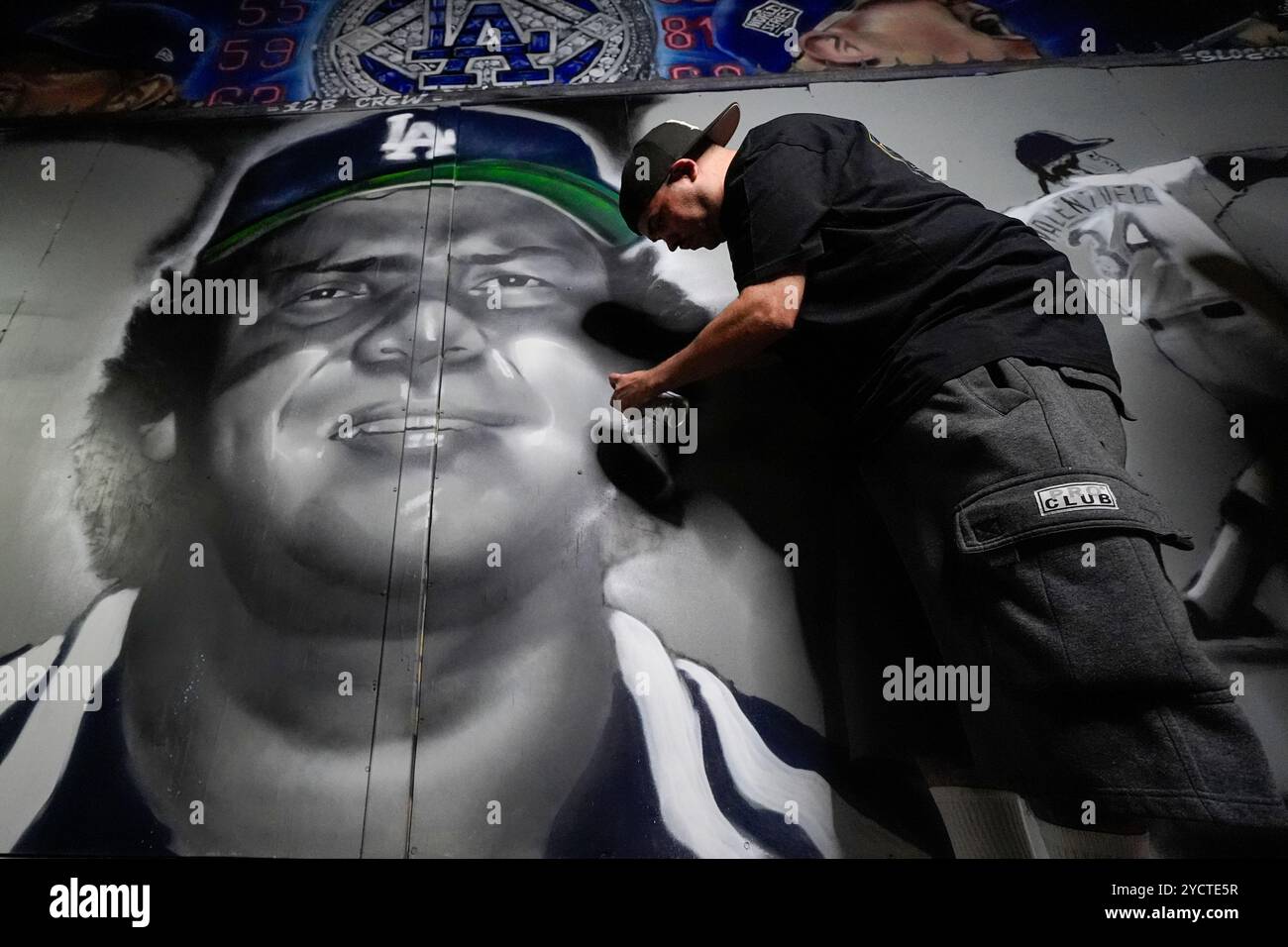 Artist Louie Palestino works on a mural depicting former Los Angeles ...